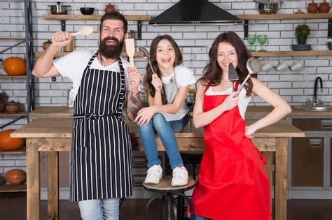 Padres mamá papá e hija cocinando comida juntos cocinan con concepto de