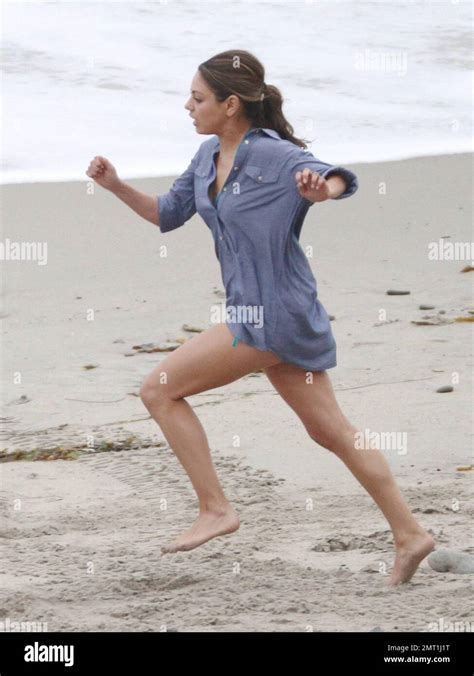 Mila Kunis Runs In Her Bikini And A Short Blue Shirt While Filming A