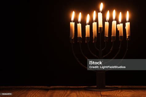 검은 배경 Hannukah 개념에 나무 표면에 Hannukah 기념일 축 하에 대 한 초를 가진 유태인 Menorah의 보기
