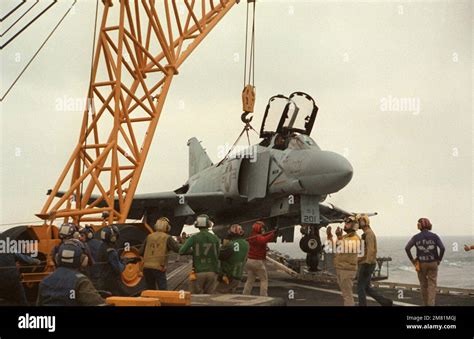 Crewman Use A Crane To Pull An F 4 Phantom Aircraft Away From The Edge