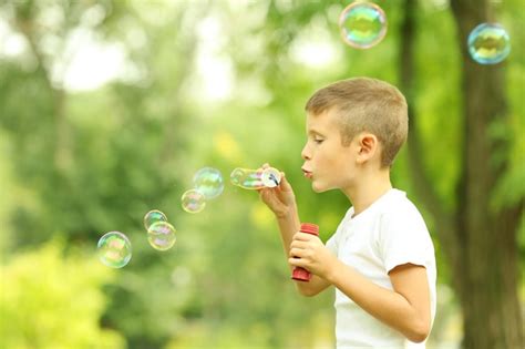 Niño Jugando Con Burbujas En El Parque Foto Premium