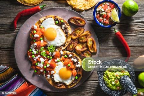 Huevos Motuleños는 피코 데 갈로와 과카몰리와 멕시코 모툴레노 계란 아침 식사 달걀에 대한 스톡 사진 및 기타