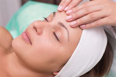 Girl Massage Therapist Does Facial Massage With A Beautiful Woman