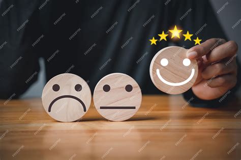 Premium Photo Hand Selecting A Smiley Face Icon On A Wood Block