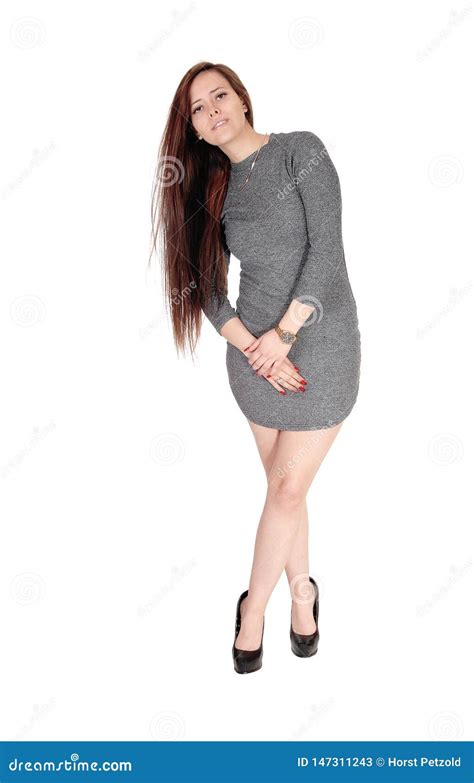 Une Jolie Position Mince De Femme Dans Une Robe Grise Image Stock