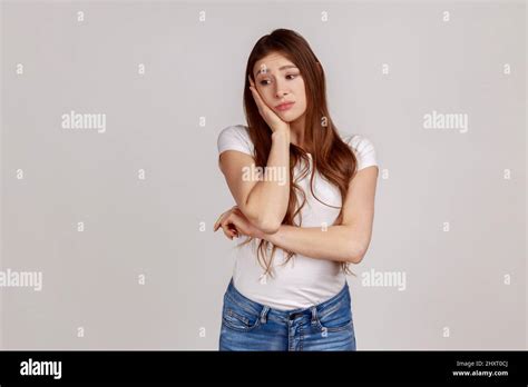 Portrait Of Bored Indifferent Thoughtful Woman Keeping Hand On Cheek
