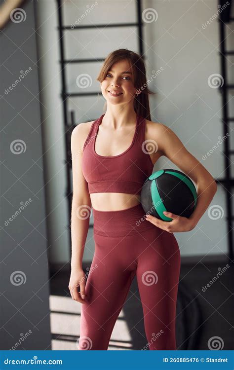 Standing And Holding Ball Young Beautiful Woman In Sportive Clothes