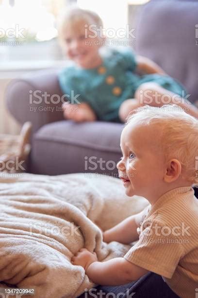소파에 앉아 어린 소녀 라운지 에 집에서 보고 Tv 로 아기 형제 재생 로 전경 2 3 살에 대한 스톡 사진 및 기타 이미지
