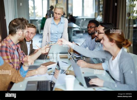 Enthusiastic Male And Female Programmers Creating New Computer Application While Sitting In