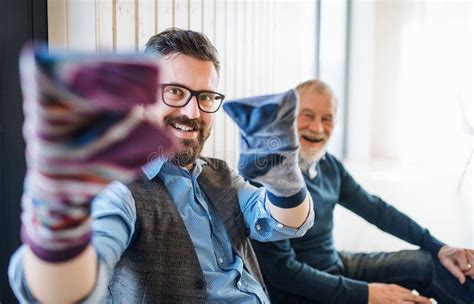 Portrait Of Adult Hipster Son And Senior Father Sitting On Floor