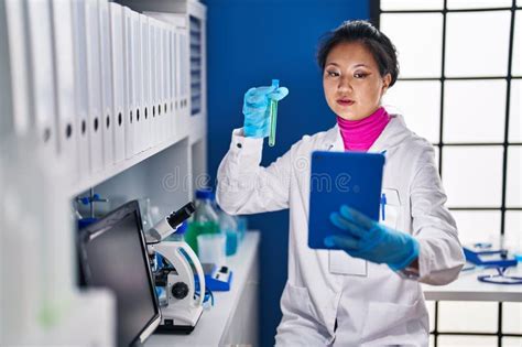 Young Chinese Woman Scientist Holding Test Tube Having Video Call At