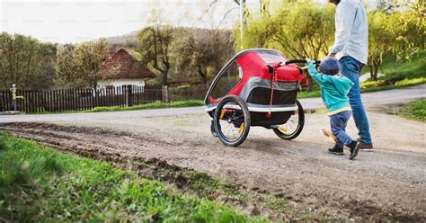 어린 아들을 둔 아버지가 조깅 유모차를 밖으로 밀고 있다 봄의 자연 속을 산책합니다 사진 Unsplash의 건강한 라이프 스타일 이미지