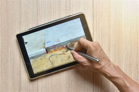 목재 테이블에 디지털 펜이있는 건축 드로잉 디자인 세부 사항의 손 스케치를 보여주는 태블릿 디지털 펜으로 태블릿 작업을위한 새로운 기술의 개념 40 44세에 대한 스톡 사진