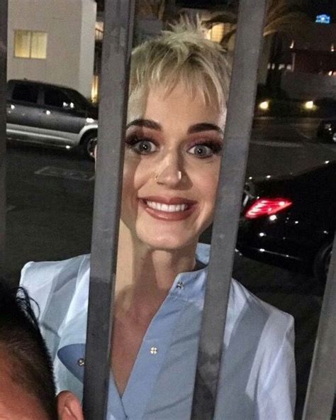 A Woman Behind Bars Smiling At The Camera While Another Man Looks On