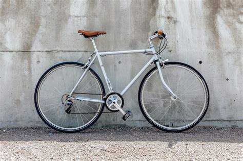 Premium Photo A White Bicycle Is Propped Against A Plain Concrete