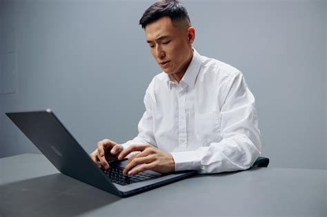 Premium Photo Man Working On A Laptop Sitting At A Table In The Office Lifestyle