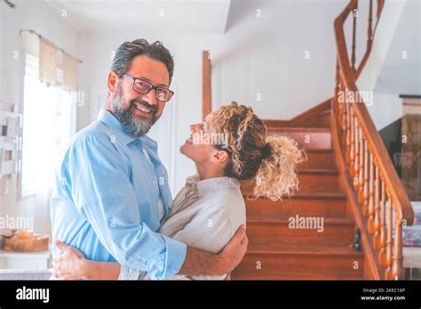 Happy Caucasian Couple Embracing Each Other In The Living Room Loving