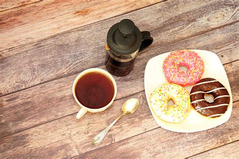 뜨거운 홍차 주전자 나무 테이블에 여러 가지 색상의 유약에 신선한 도넛 3 개가있는 접시 갈색에 대한 스톡 사진 및 기타 이미지 Istock