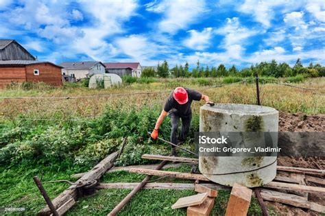 작업자가 강철 파이프와 보드로 만든 롤러 데크를 사용하여 콘크리트 링을 이동합니다 50 59세에 대한 스톡 사진 및 기타 이미지 50 59세 55 59세 공사장 인부