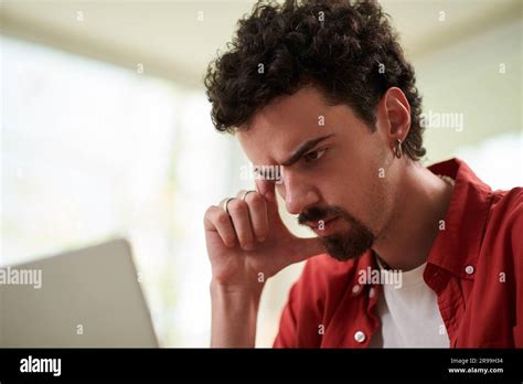 Pensive Man Checking Programming Code For Errors When Working On Laptop
