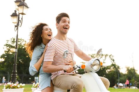 Portrait Of Man And Woman Riding On Motorbike Together Through City