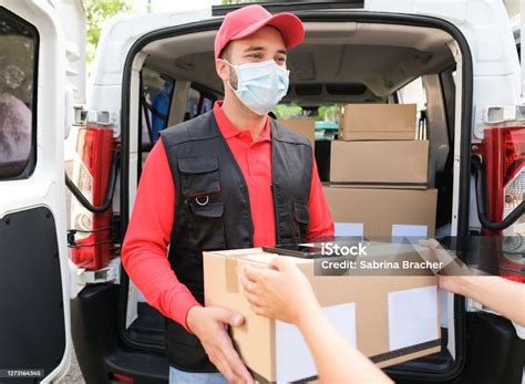 배달 남자로부터 패키지를받는 여자 코로나 바이러스 안전 조치에 대한 직장에서 수술 얼굴 마스크를 착용 하는 젊은 남자 배달에 대한 스톡 사진 및 기타 이미지 Istock