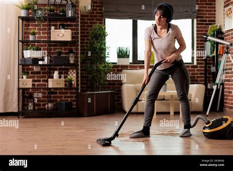 Modern Woman Using Vacuum Cleaner Listening To Favorite Music With