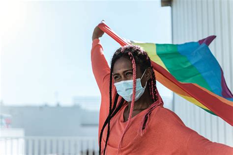 자부심 이벤트에서 Lgbt 무지개 깃발을 들고 안전 마스크와 젊은 아프리카 레즈비언 얼굴에 초점 성 평등에 대한 스톡 사진 및