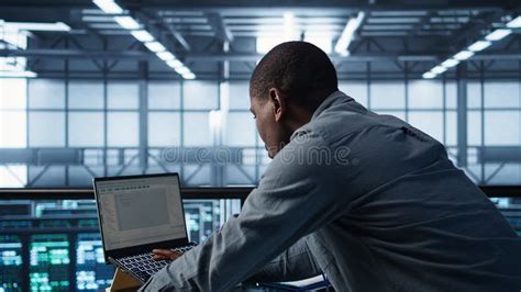 technician in data center using programming languages on laptop stock