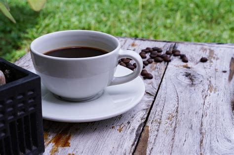 오래된 나무 테이블에 뜨거운 아메리카노 커피 접시에 커피 한 잔 아메리카노 블랙 커피 나무 바닥에 커피 컵 오후는 커피를 마시는 가장 좋은시기입니다 0명에 대한 스톡 사진