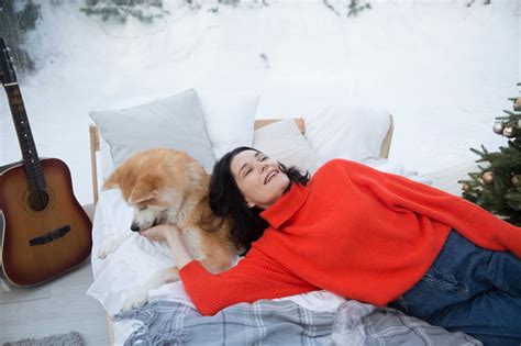 겨울 방학에 Glamping 집에서 휴식을 취하고 시간을 보내는 개를 가진 중년 여성 새해 복 많이 받으세요 50 54세에 대한