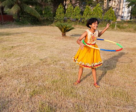 A Little Indian Girl Playing In Park With Hula Hoop By Stocksy