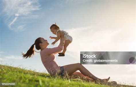 함께 즐거운 여름 날을 즐기고 잔디에 앉아 그녀의 아이를 숭배하는 엄마 부모 어머니에 대한 스톡 사진 및 기타 이미지 어머니 풀 벼과 헌신 Istock