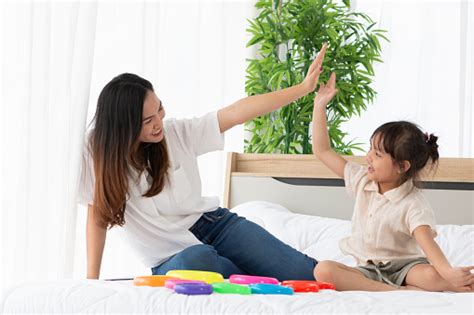 엄마와 딸은 침대에서 5 를하고 그들은 아침에 함께 놀고있다 엄마와 딸은 집에 검역을하는 동안 함께 게임을 하기 위해 5 일차