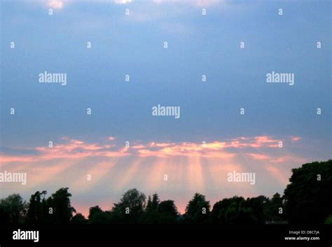 This Image Captures Sunlight Filtering Through Clouds Creating Dramatic Beams Of Light The