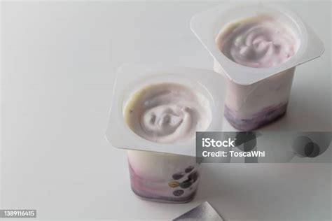 복사 공간이있는 흰색 배경에 고립 된 맛있는 디저트 또는 흰색과 블루 베리 요구르트 크림플라스틱 용기의 최고 보기 요구르트