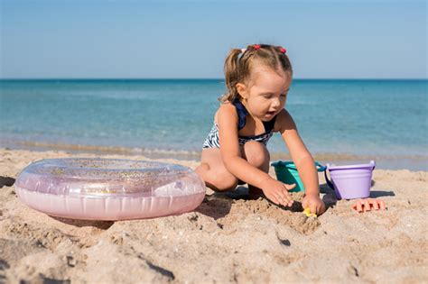여름 날 해변에서 모래와 함께 노는 어린 소녀 아이들은 해안 바다에 삽과 양동이와 모래 조각을 구축 재미있는 가족 휴가 개념 2