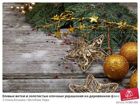 Еловые ветки и золотистые елочные украшения на деревянном фоне