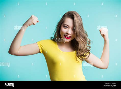 Portrait Of Cheerful Young Woman Raising Her Fists With Smiling
