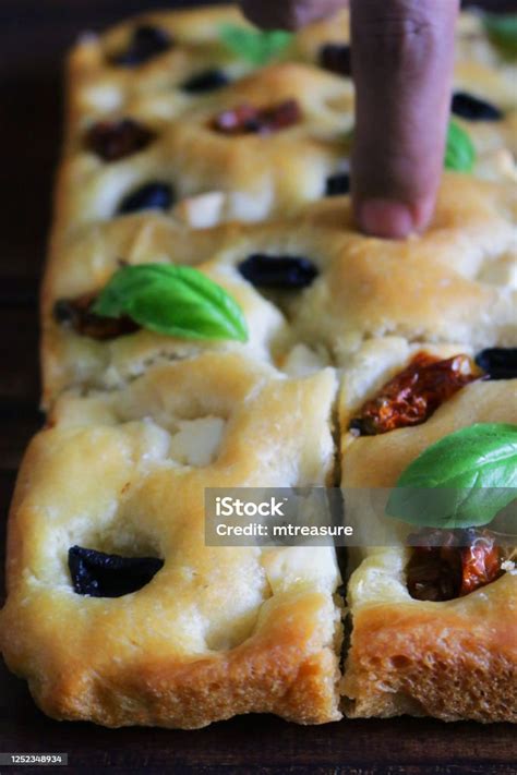 나무 도마에 슬라이스 수제 이탈리아 어 Focaccia 빵 덩어리의 이미지 녹색 올리브 햇볕에 말린 토마토와 바질 잎 장식 인식