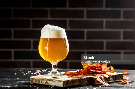 두꺼운 거품공예 맥주의 서리가 내린 유리 나무 배경에 말린 생선 맥주 양조장 개념 맥주 말린 제련소를 위한 간식 맥주 배경