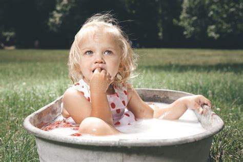 Small Lady Bathing In Sheet Metal Retro Bath Tub In Summer Park Stock
