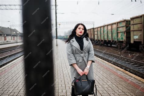 Premium Photo Brunette Girl In Gray Coat Posed In Railway Station