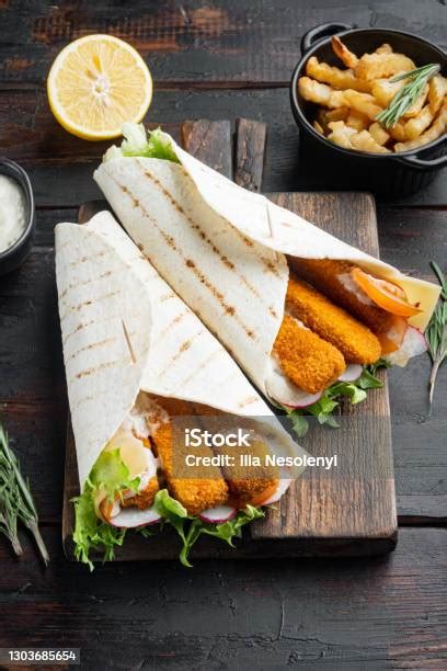 오래된 어두운 나무 테이블 배경에 나무 도마에 물고기 손가락 치즈와 야채와 토르티야 롤 가지 식물 부위에 대한 스톡 사진 및 기타 이미지 가지 식물 부위 감자 칩