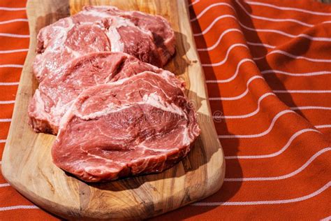 Fresh Rib Eye Steaks On A Wooden Cutting Board And Red And White