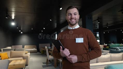 A Sales Assistant Explains The Features Of A Hedge Trimmer To A