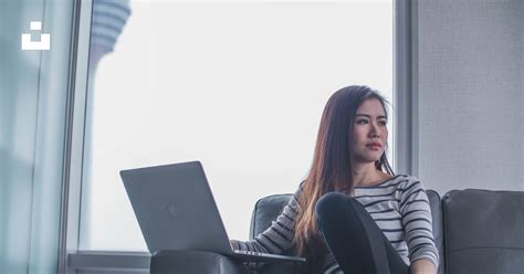 노트북 컴퓨터를 사용하는 동안 소파에 앉아있는 여자 사진 Unsplash의 무료 소파 이미지