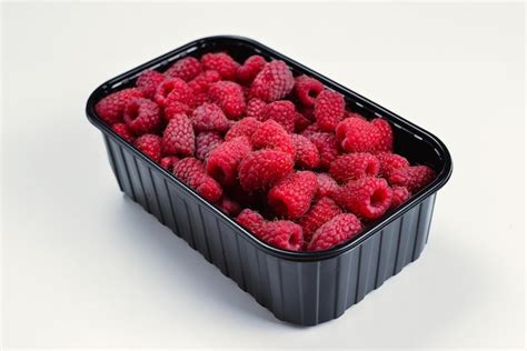 Premium Photo Raspberry In Black Container Isolated On White Background