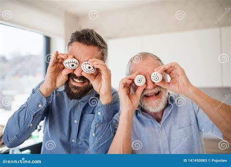 A Portrait Of Adult Hipster Son And Senior Father Indoors At Home
