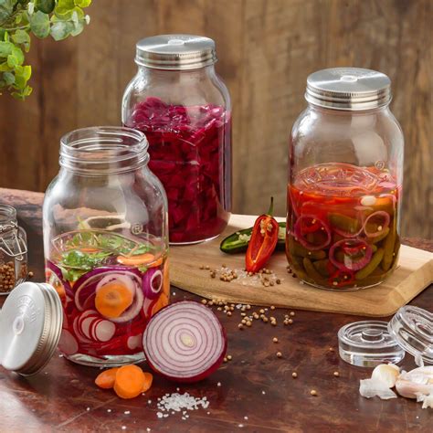 Three Jars Filled With Food Sitting On Top Of A Wooden Table Next To